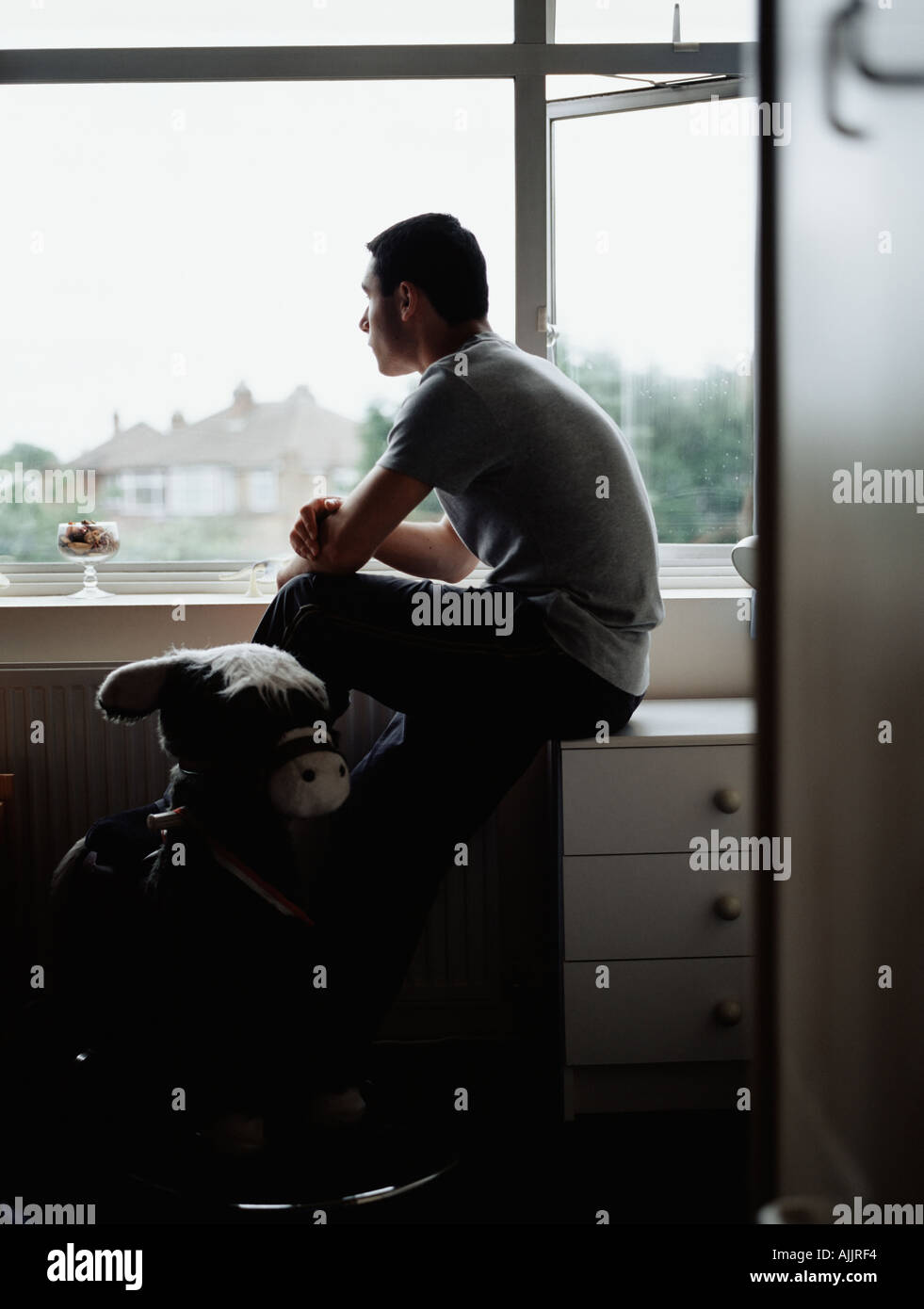 Silhouetted boy near window Stock Photo - Alamy