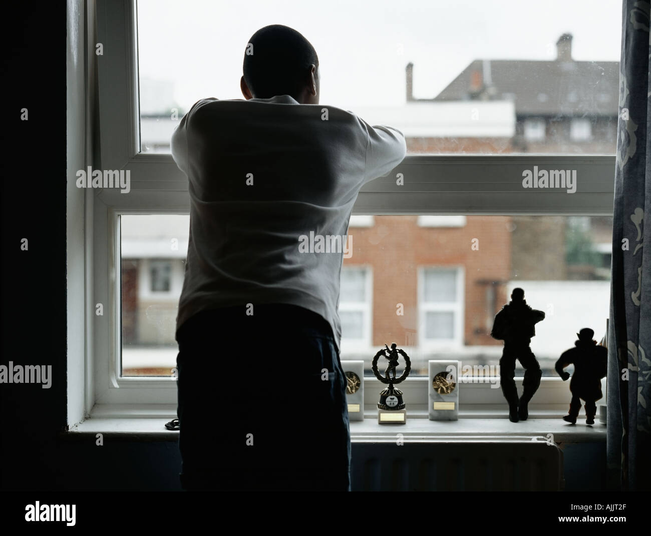 Silhouetted boy near window Stock Photo - Alamy