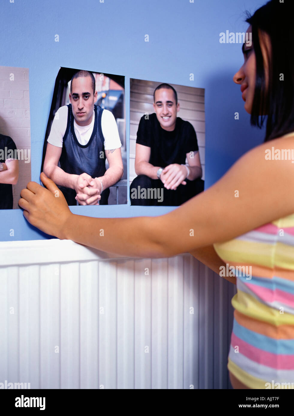 Girl attaching posters to wall Stock Photo - Alamy