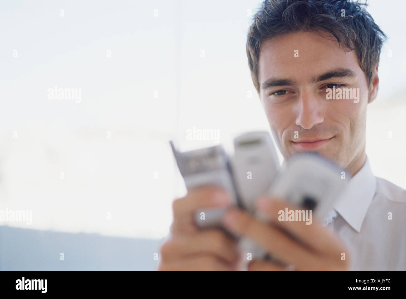 Man choosing between mobile phones Stock Photo - Alamy