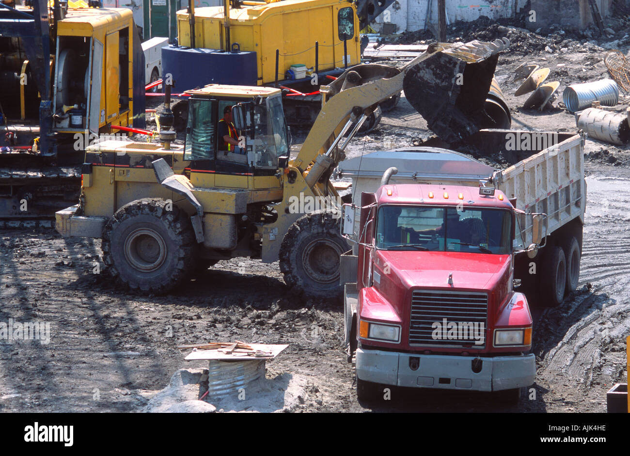 Front loader and truck at construction site Stock Photo - Alamy
