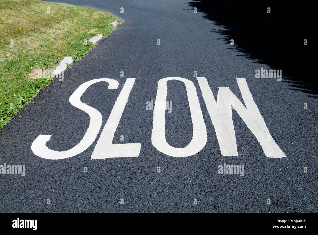 slow painted onto tarmac road Stock Photo - Alamy