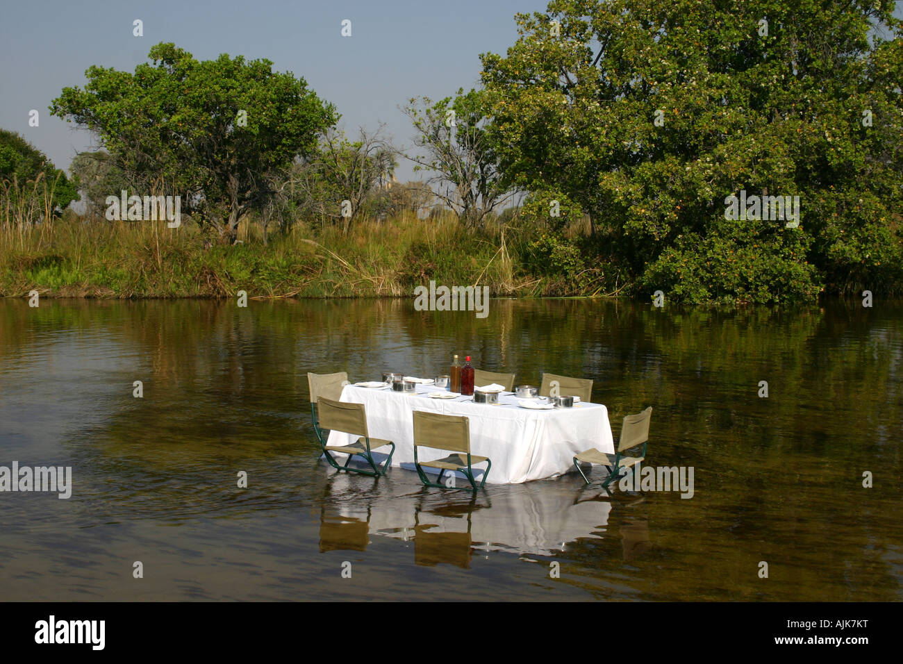 A dining table set up for lunch in a river in the Okavango Delta ...