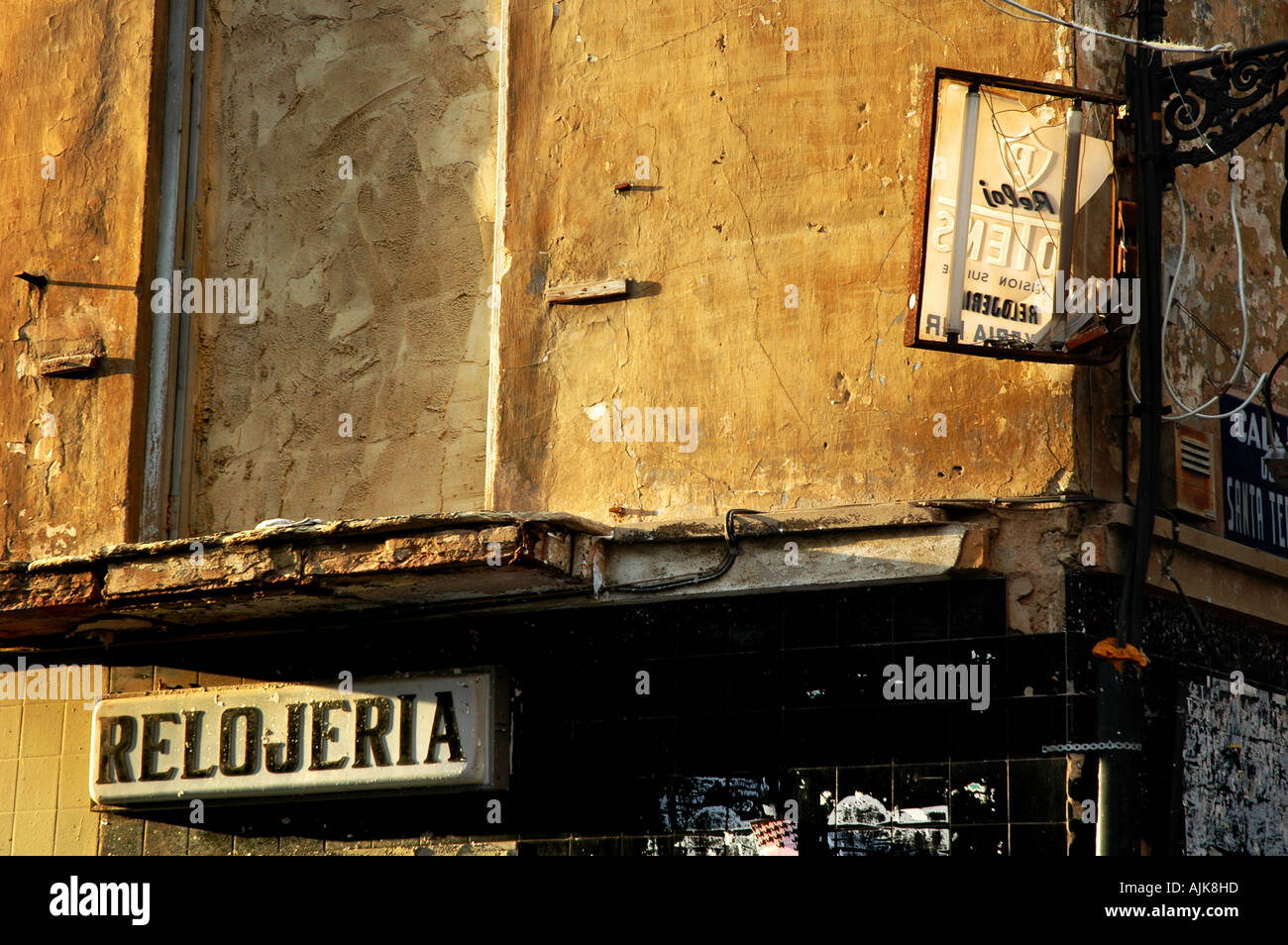 derelict watch and clock shop with broken electric sign lit by early ...