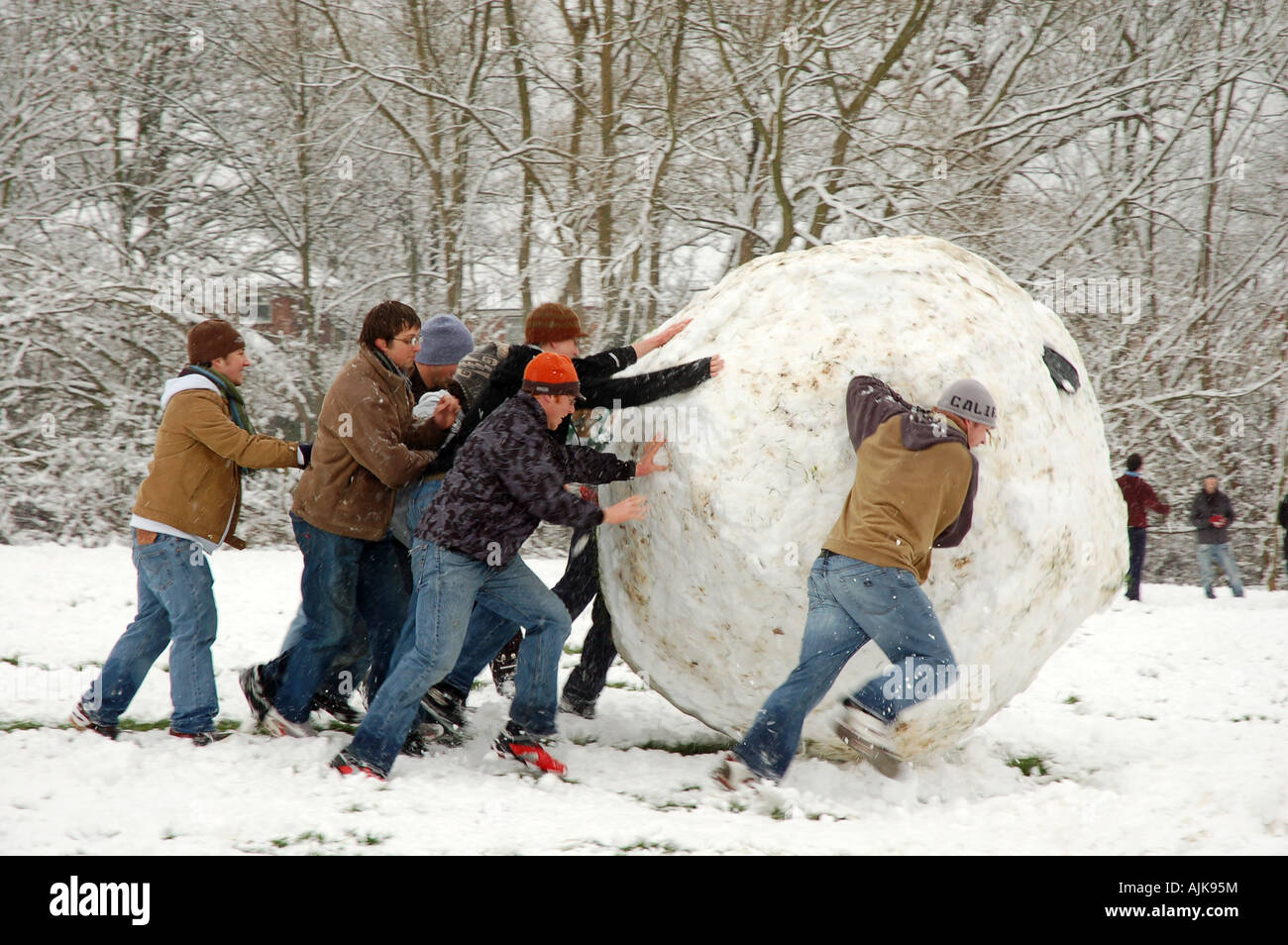 Boys rolling a giant snow ball in South Park Oxford Stock Photo - Alamy