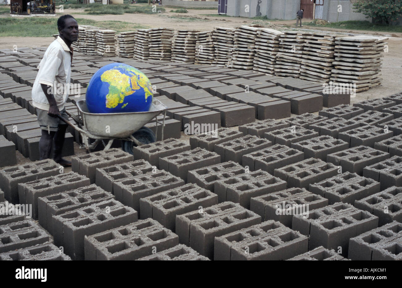 African construction worker with large globe in wheelbarrow Stock Photo ...