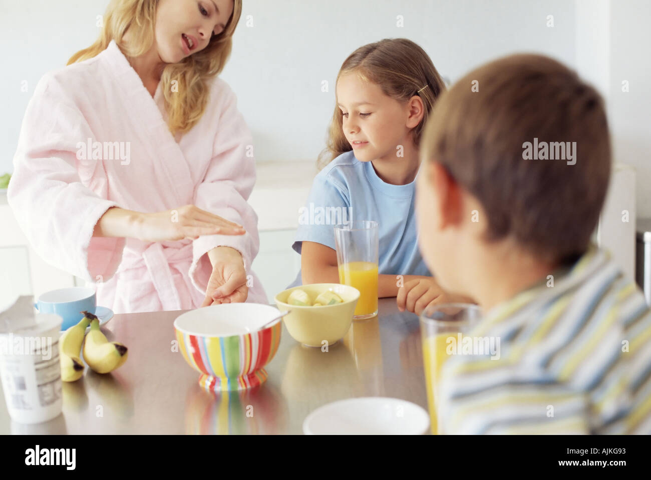 Mother and children having breakfast Stock Photo - Alamy