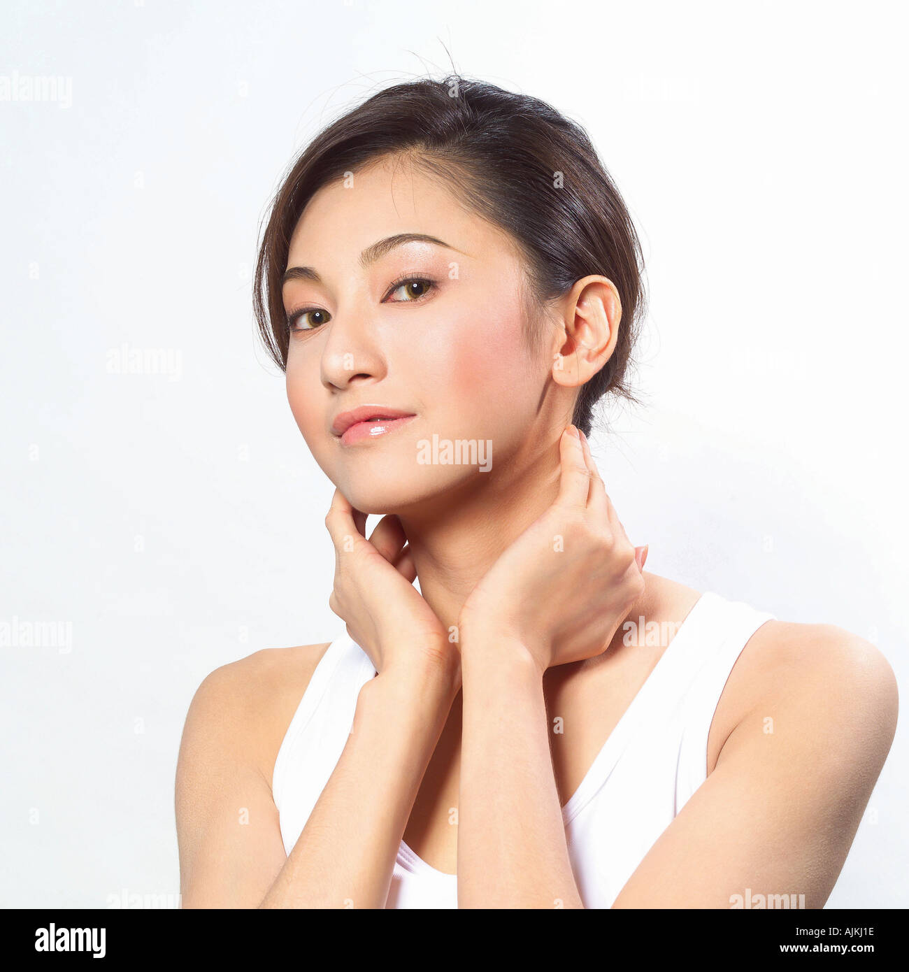 Portrait of a young woman holding her neck Stock Photo - Alamy
