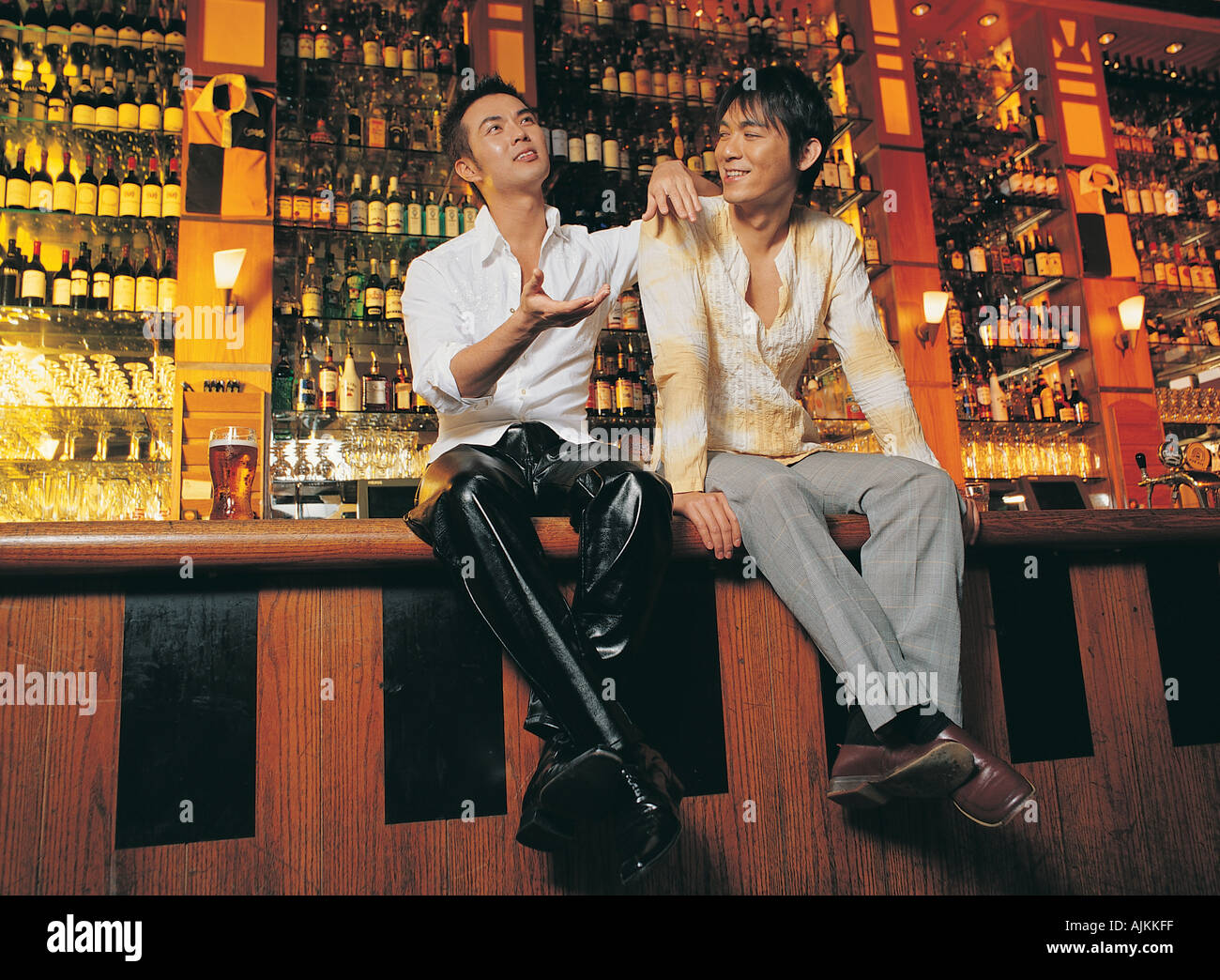 Low angle view of two young men in a bar Stock Photo - Alamy