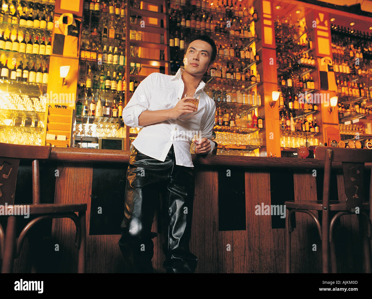 Young man standing at the counter in a bar Stock Photo - Alamy