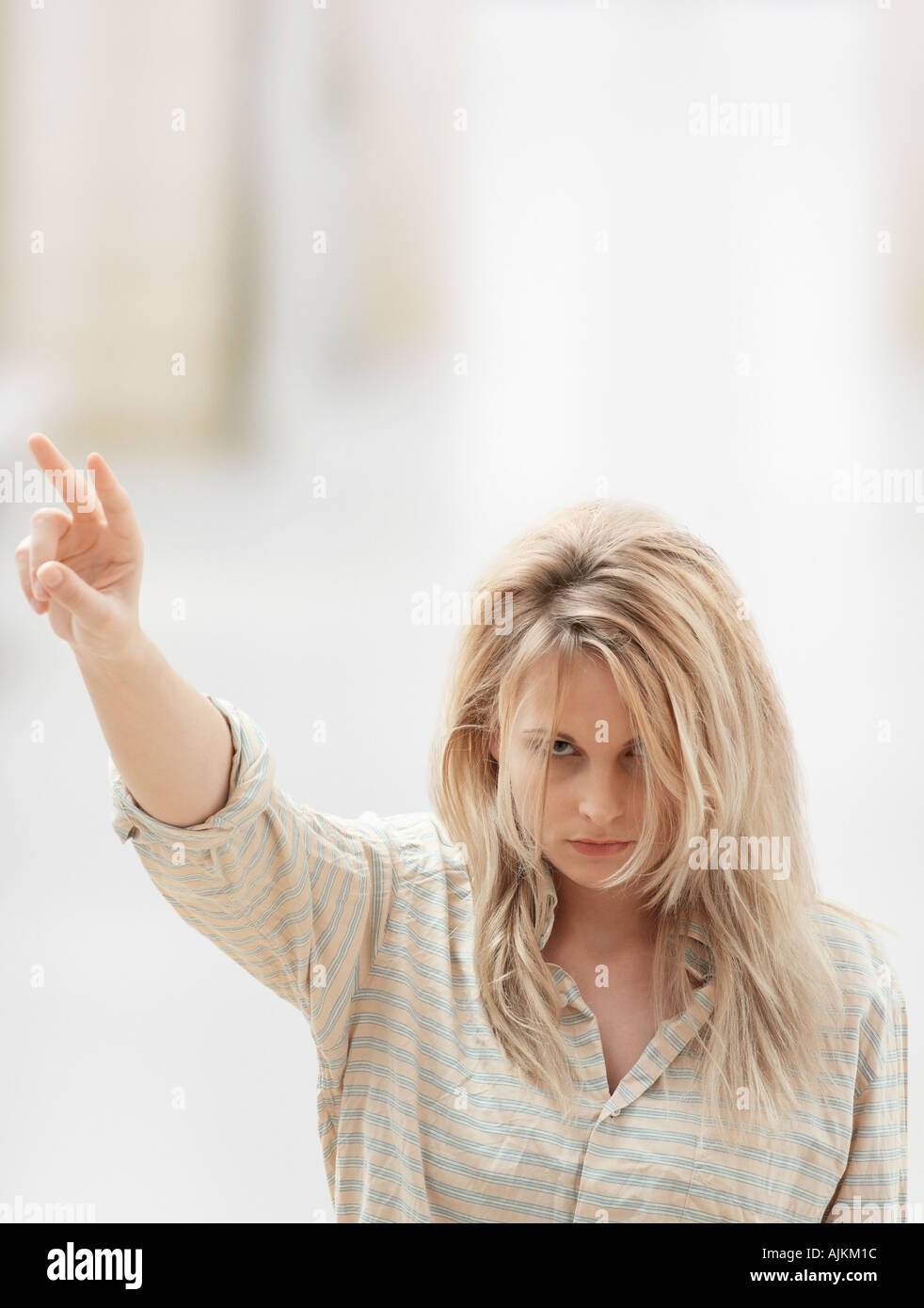 Woman making peace sign Stock Photo - Alamy