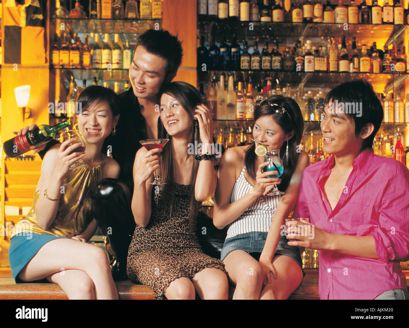 Group of young men and women in a bar Stock Photo - Alamy