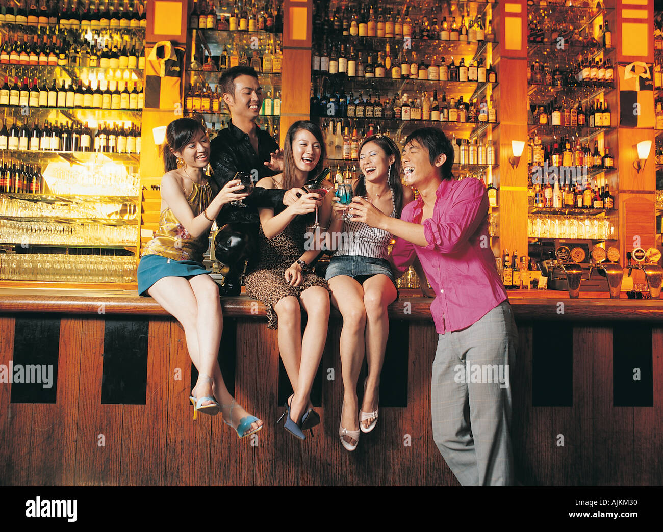 Group of young men and women in a bar Stock Photo - Alamy