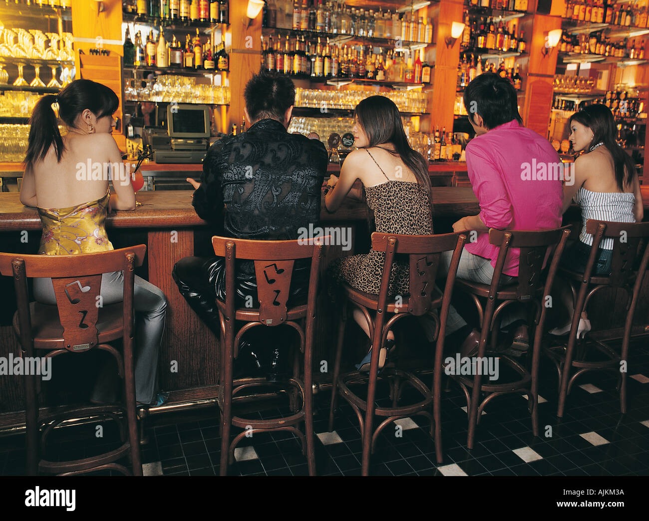 Rear view of a group of young men and women in a bar Stock Photo - Alamy
