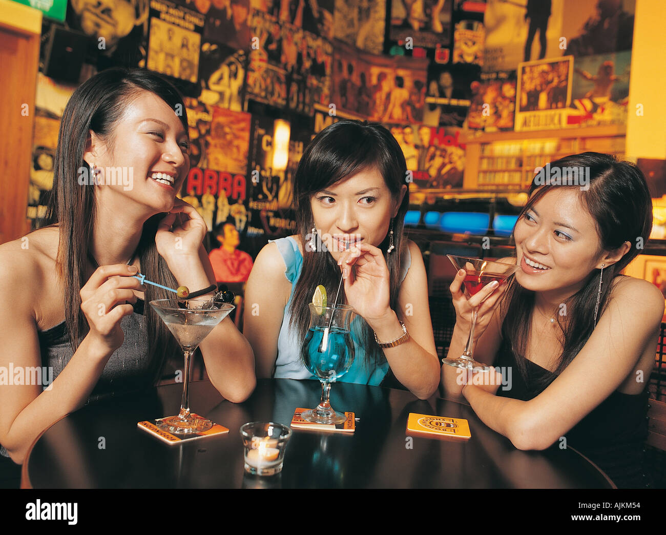 Three young women drinking cocktails in a bar Stock Photo - Alamy