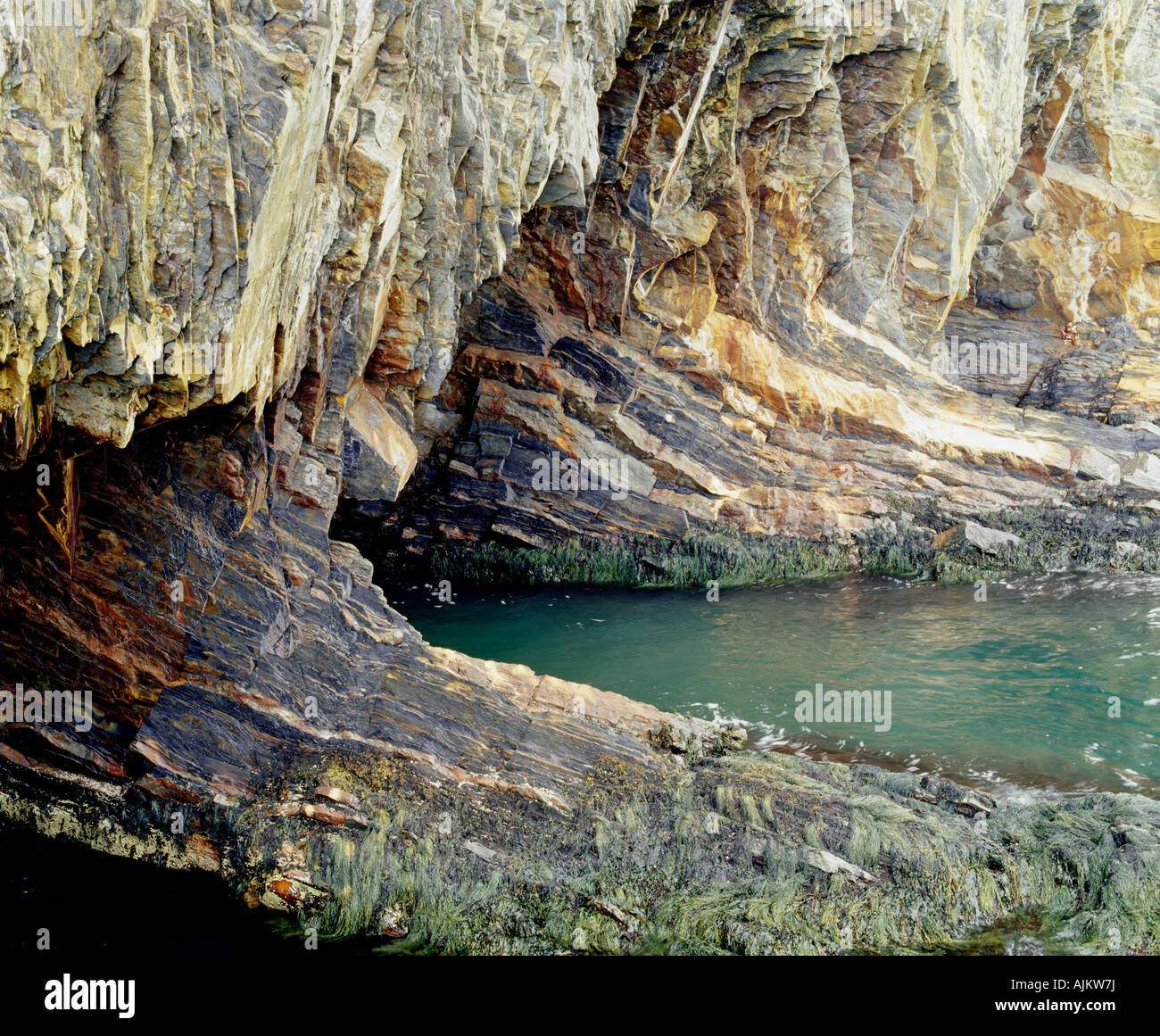 Rocky cave with water flowing into it Stock Photo - Alamy