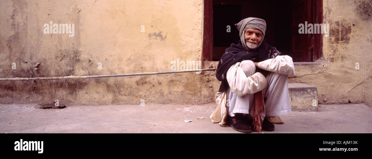 Indian man crouching on wall, old Delhi, India Stock Photo - Alamy