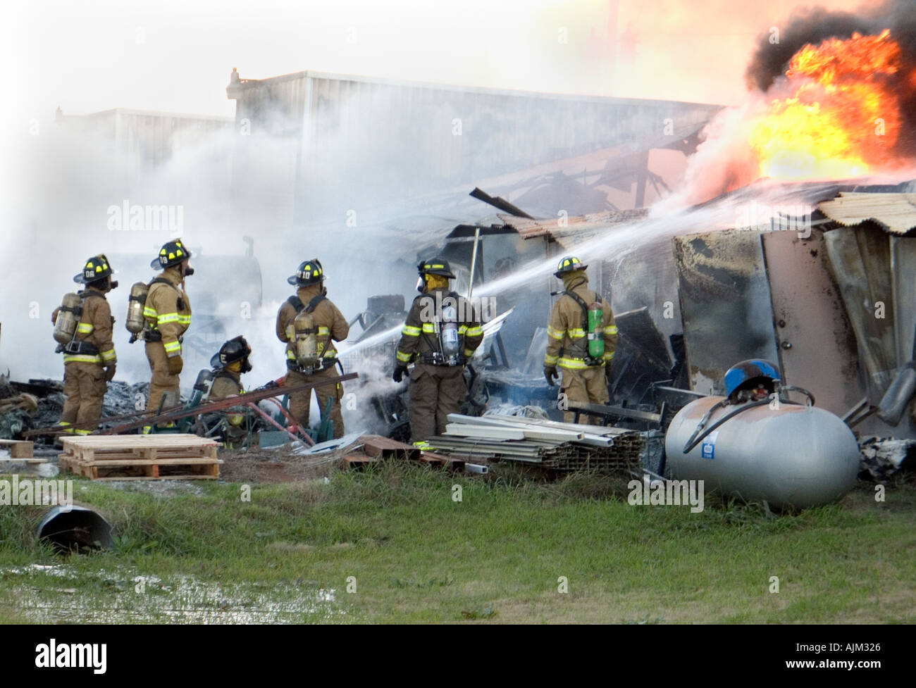 Team of fire fighters working an industrial fire Stock Photo - Alamy