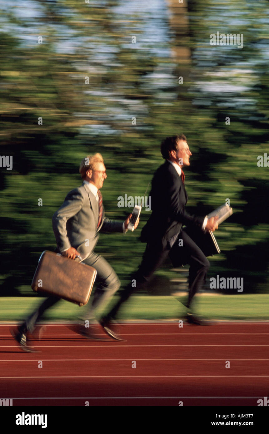 Copyright James Kay Businessmen running neck and neck on running track ...