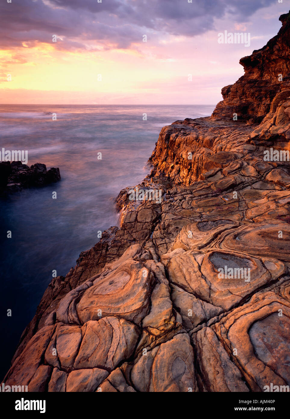 Tesselated rock caught in the early warming rays of the Sun, Wollongong ...