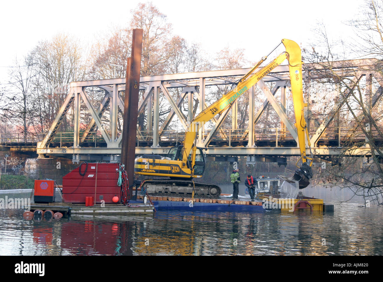 Floating excavator digging in a river Stock Photo - Alamy