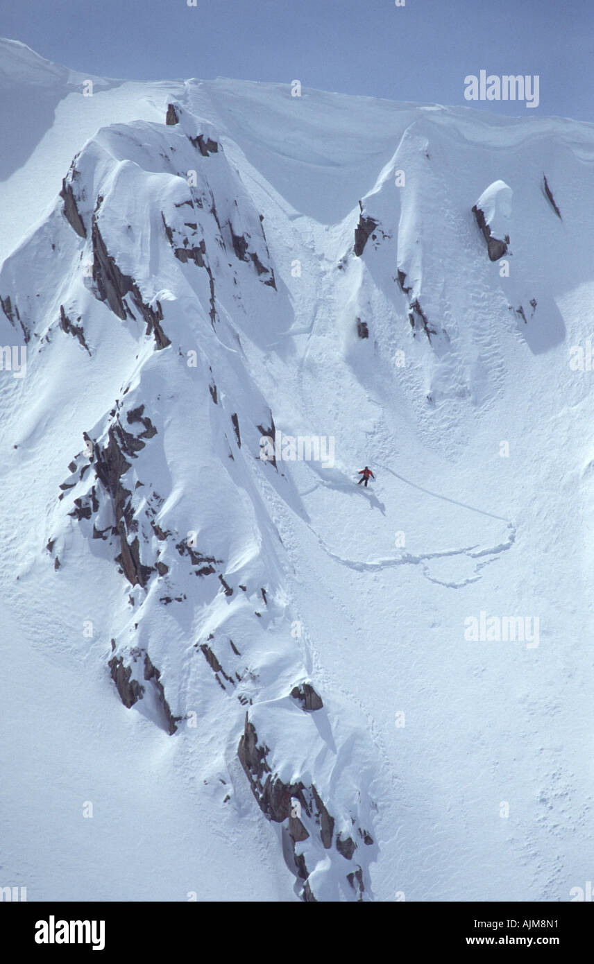 A man starting an avalanche while snowboarding in Wolverine Cirque UT ...