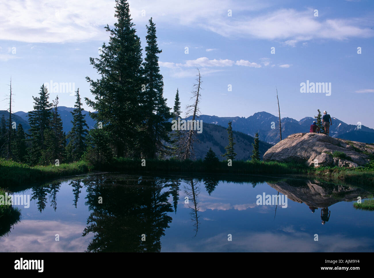 Hikers on trail along back country lake Indian Peaks Wilderness CO ...
