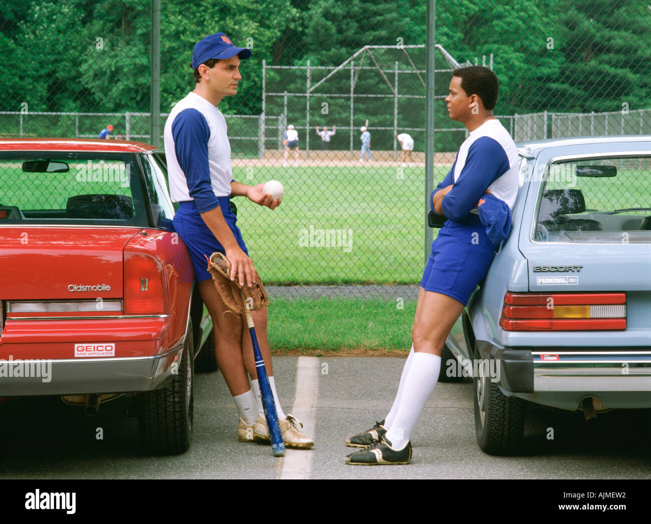 Two men talking by their cars before baseball game Stock Photo - Alamy