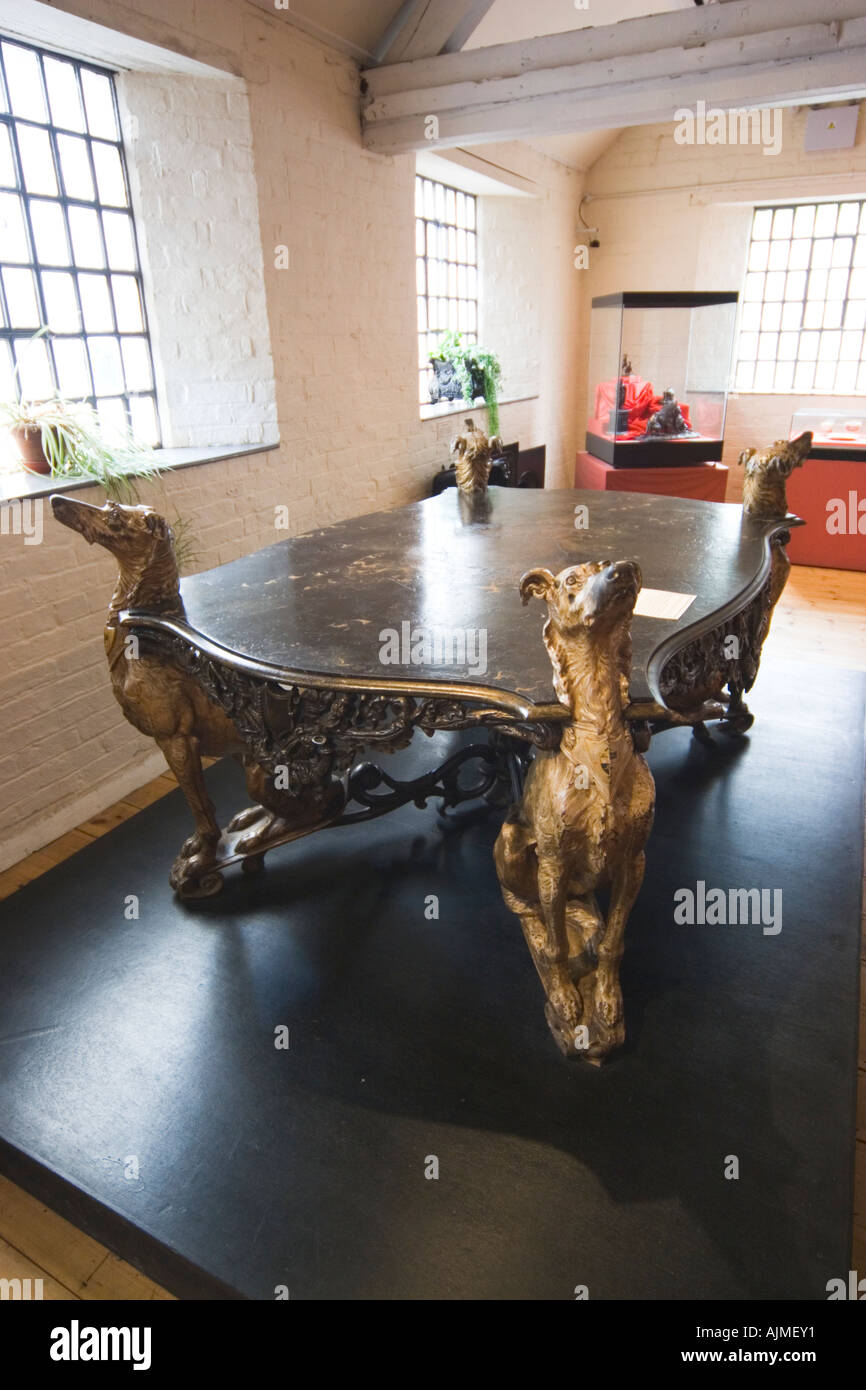 Iron table with four dog hound holing table top Stock Photo - Alamy