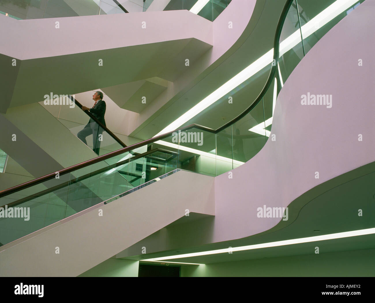 Executive alighting an escalator Stock Photo - Alamy