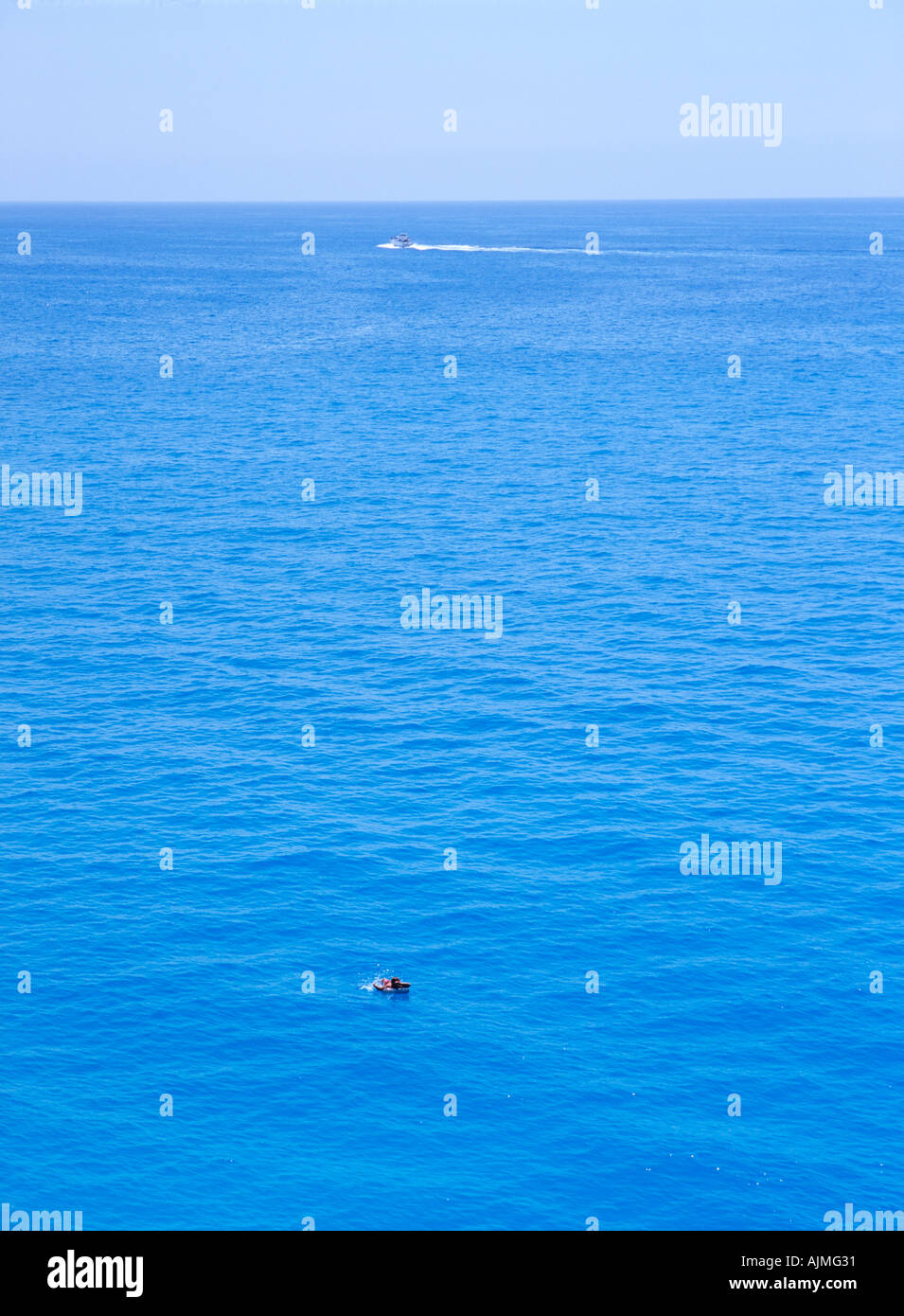 Swimmer in beautiful sea with a boat in far distance Stock Photo - Alamy