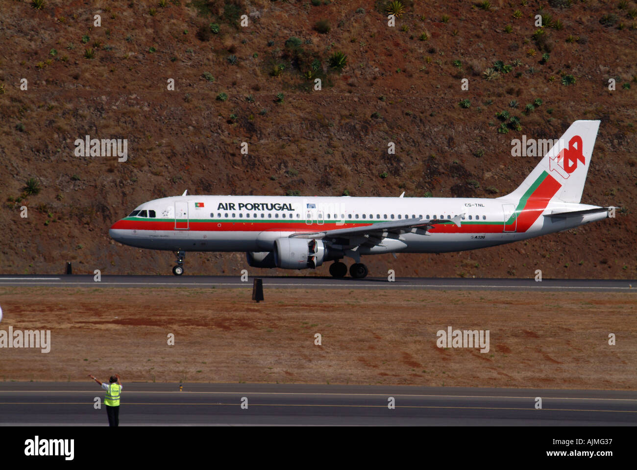 Airport worker guides Airliner to parking stand Stock Photo - Alamy