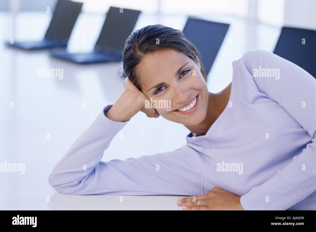Woman leaning on desk Stock Photo - Alamy
