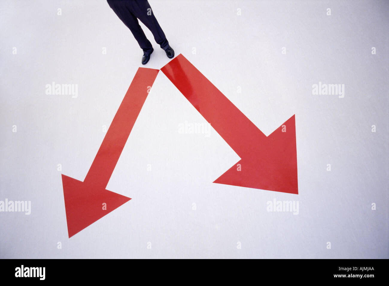 Man standing between arrows Stock Photo - Alamy