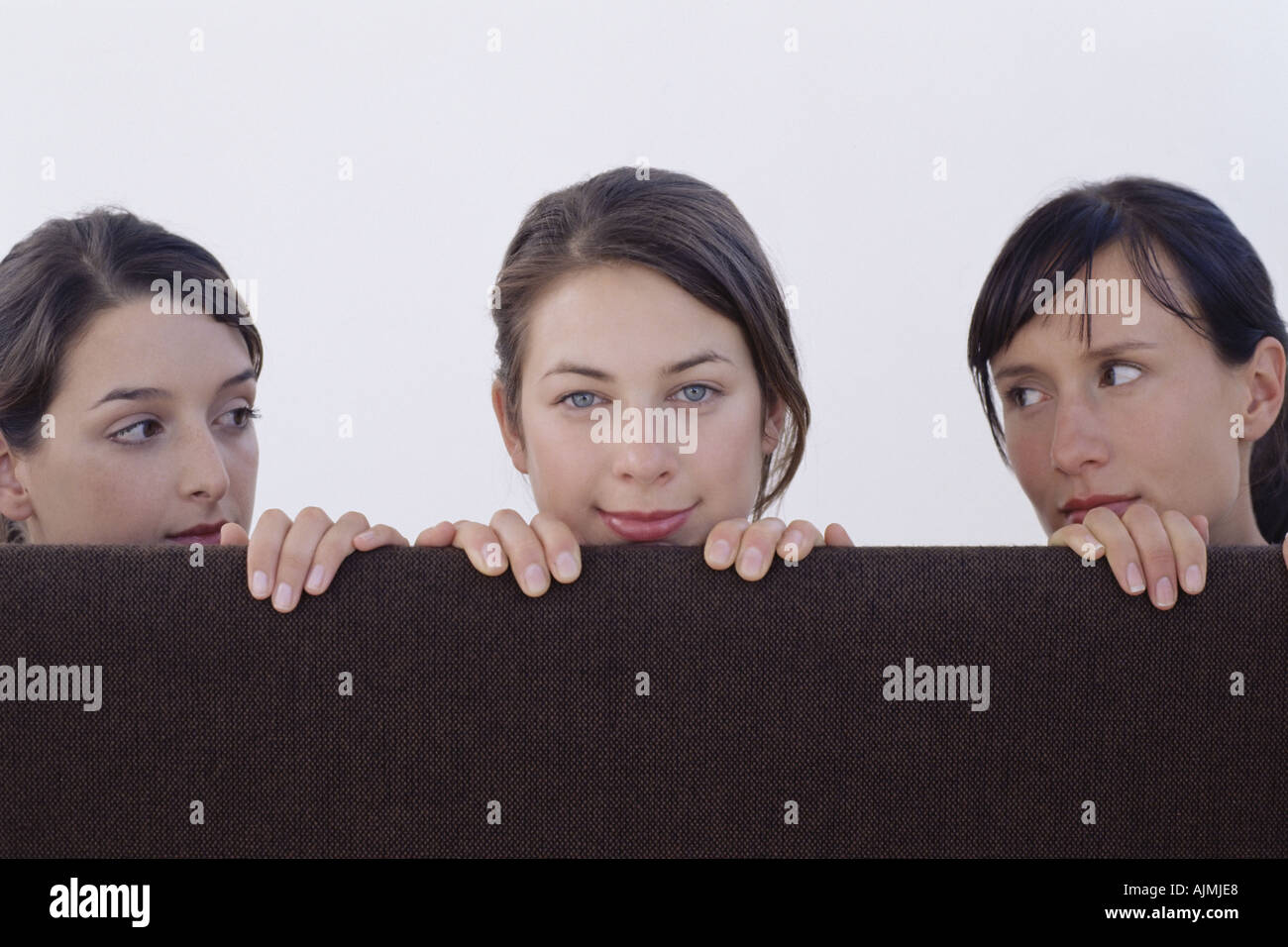Three women looking over cubicle Stock Photo - Alamy