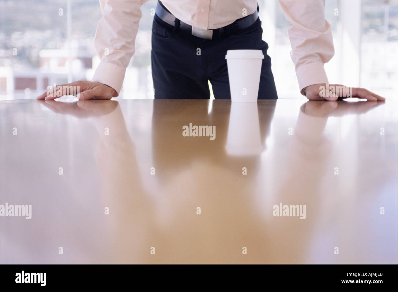 Office worker leaning on desk Stock Photo - Alamy
