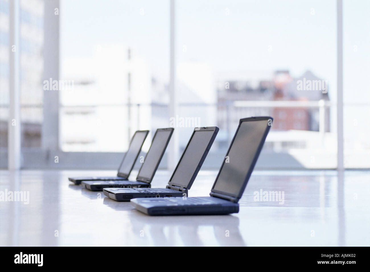 Row of laptops on a desk Stock Photo - Alamy