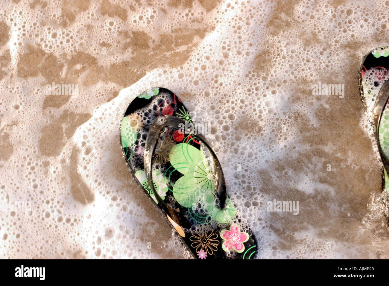 duo pair of flip flop recovering by waves beside the water of sea Stock ...