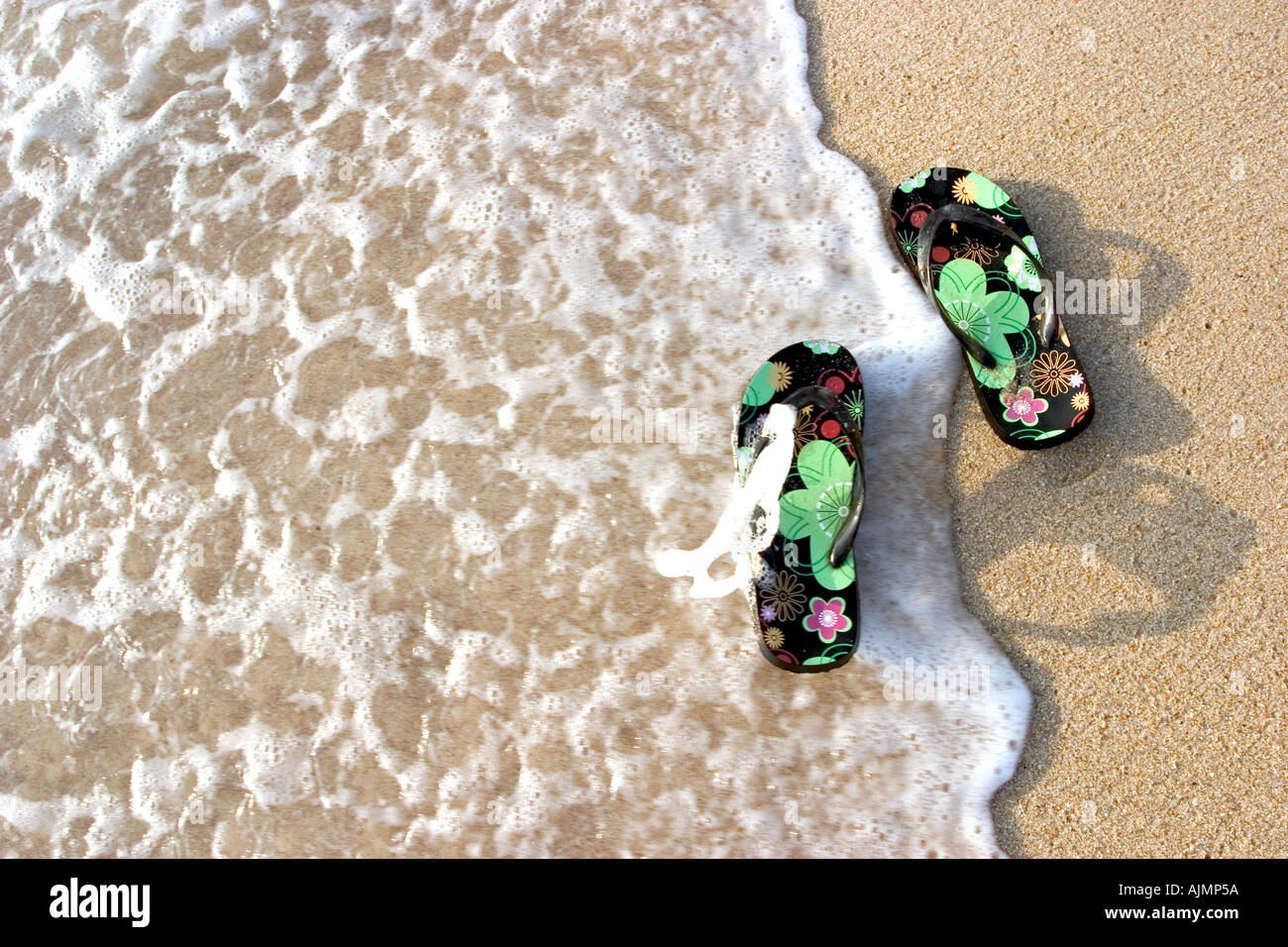 duo pair of flip flop recovering by waves beside the water of sea Stock ...