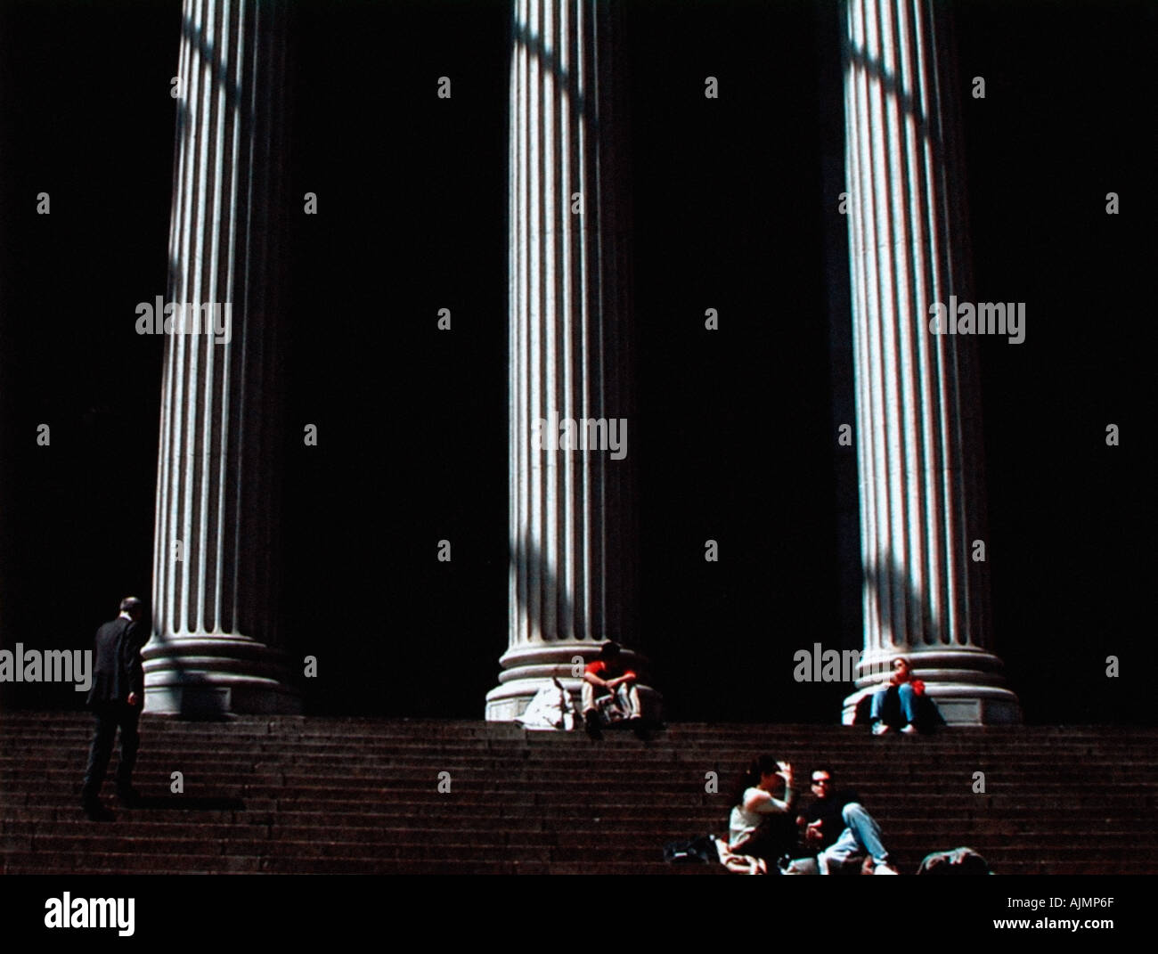 People sitting near columns Stock Photo - Alamy