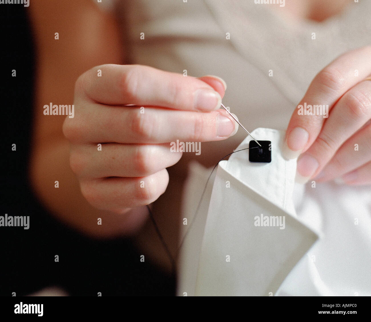 Sewing button on shirt hi-res stock photography and images - Alamy