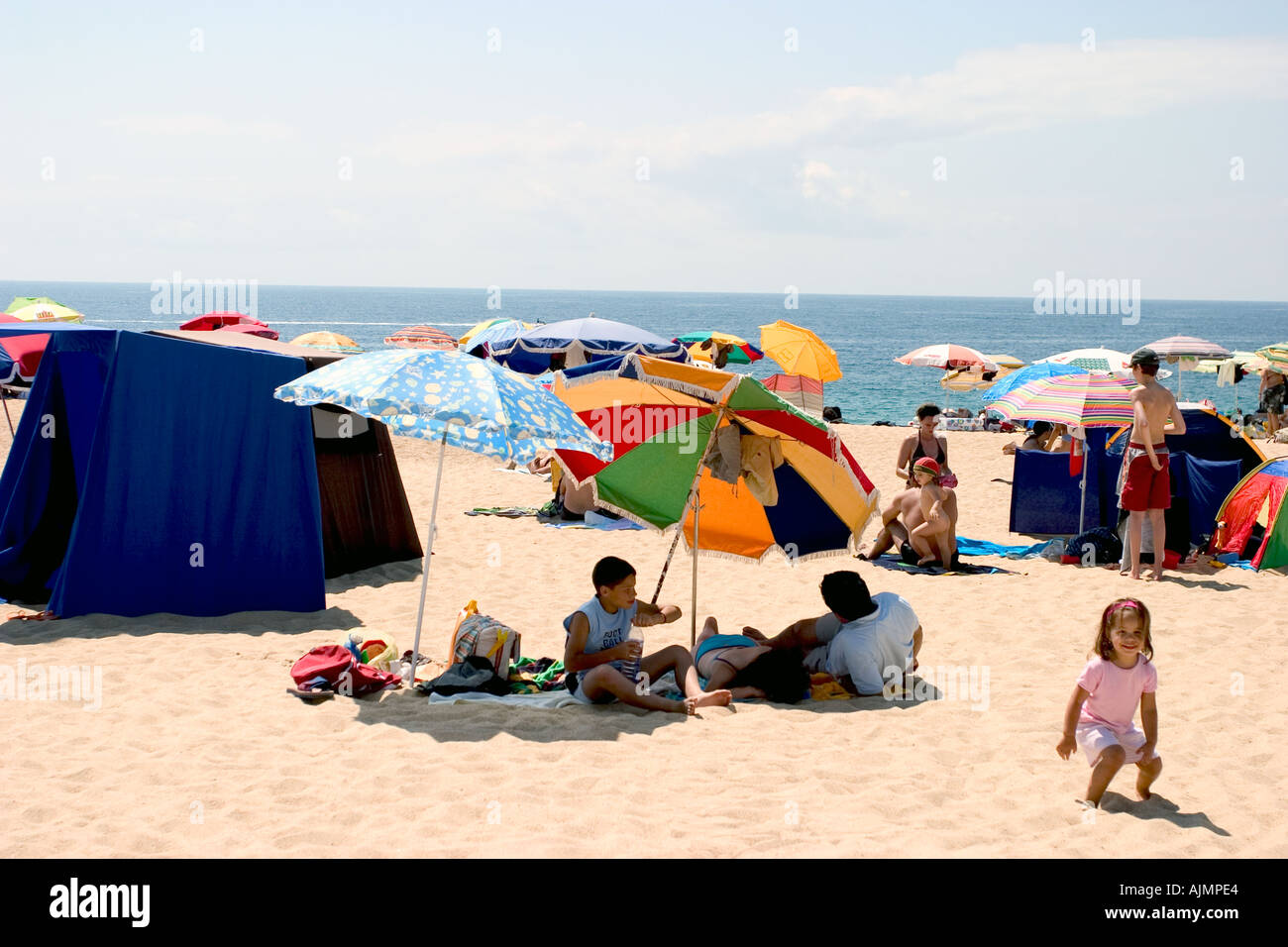 Family with colourful parasol relaxing on beach hi-res stock ...