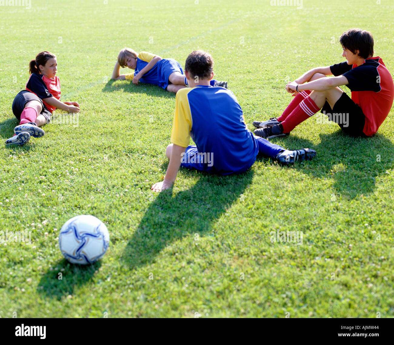 four young football players relaxing in grass Stock Photo - Alamy