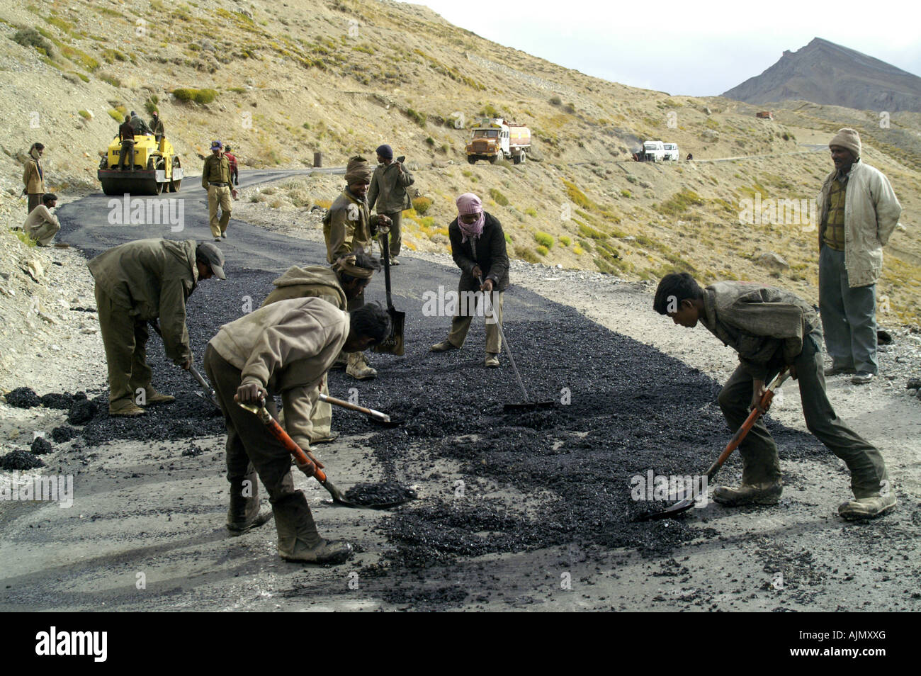 Indian men workers paving road in Ladakh, India Himalaya moutains Stock ...