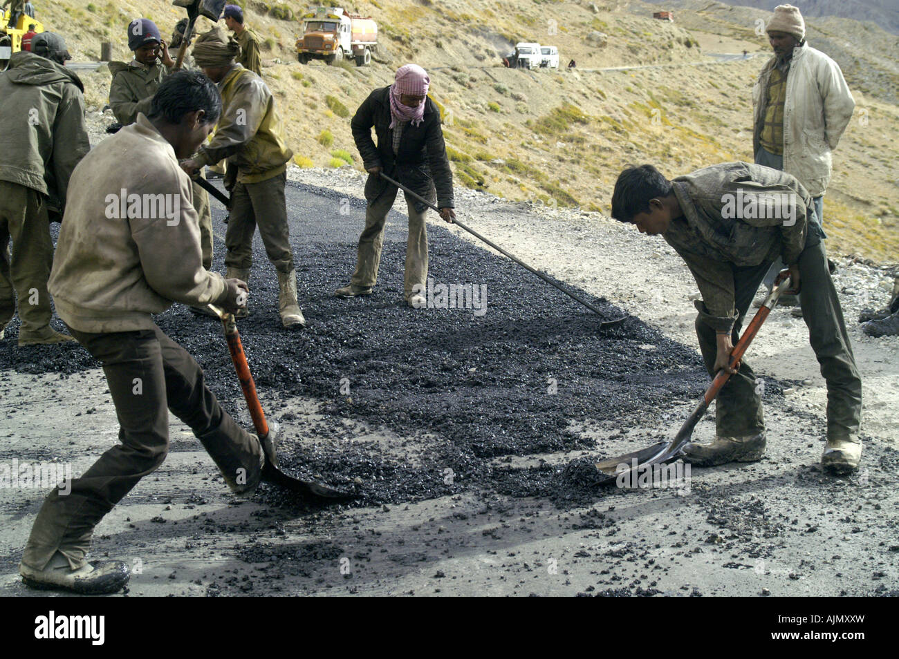 Indian men workers paving road in Ladakh, India Himalaya moutains Stock ...
