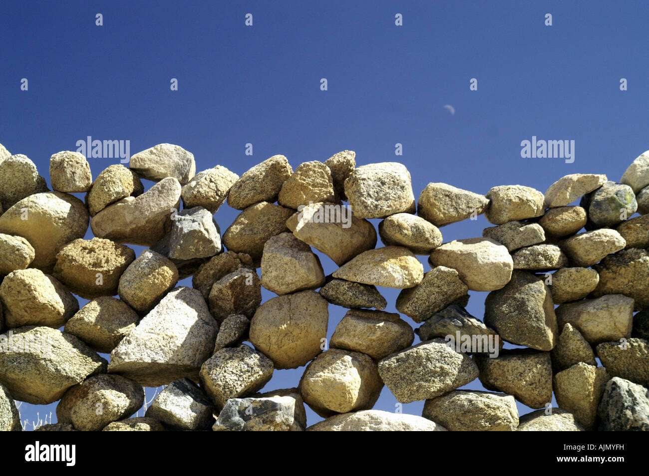 Boulders stacked forming sparse stone wall dividing fields in Ladakh ...