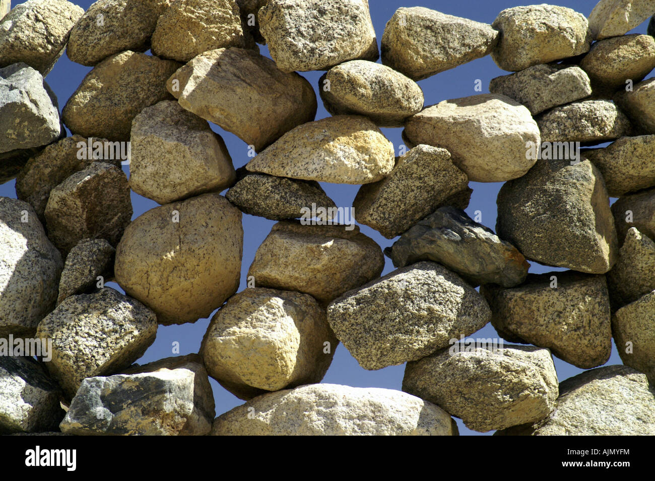 Boulders stacked forming sparse stone wall dividing fields in Ladakh ...