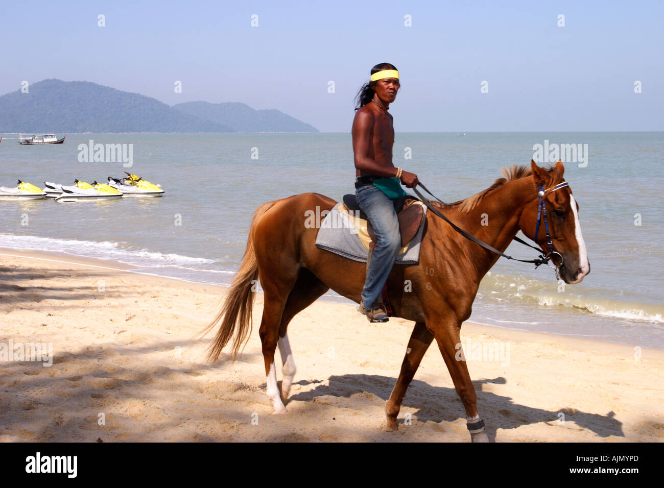 A local man offers horse rides on Batu Ferringhi beach, Penang Island ...