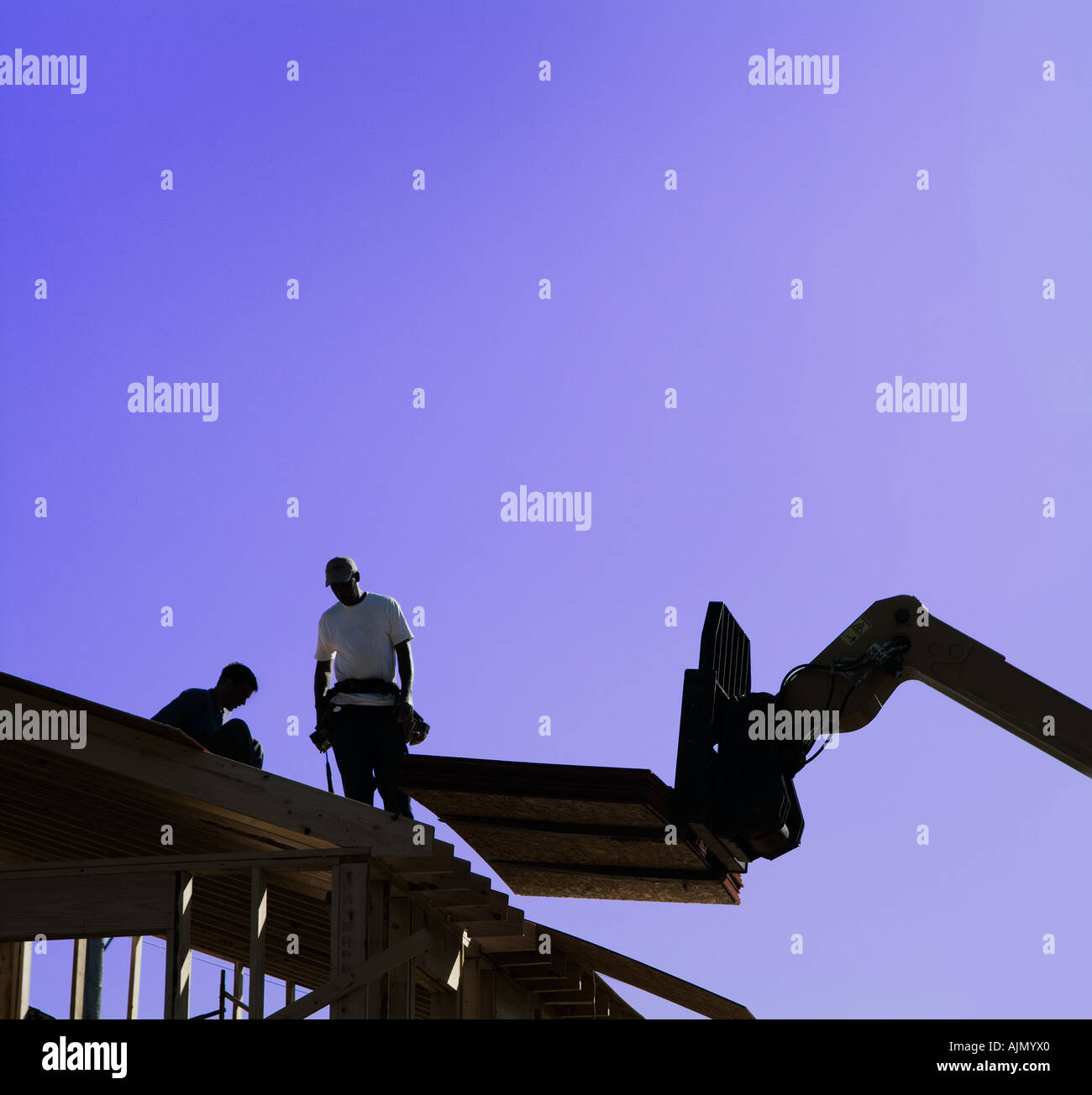 Silhouette Of Construction Workers On Roof Top Of An Incomplete House ...