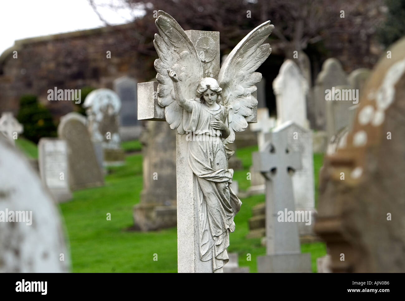 Angel gravestone seen amongst other graves Stock Photo - Alamy